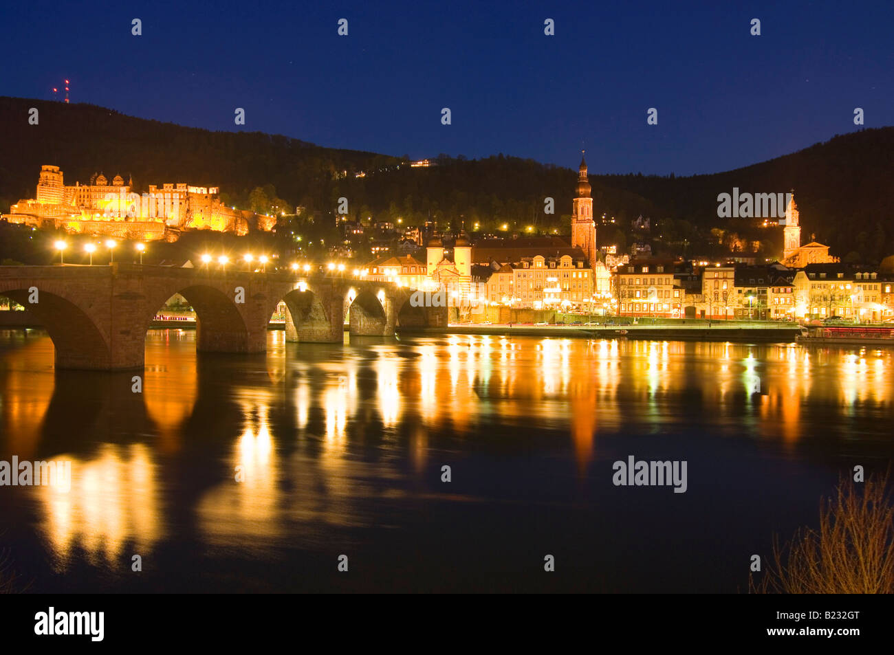 Arch bridge across river lit up at night, River Necker, Germany Stock ...