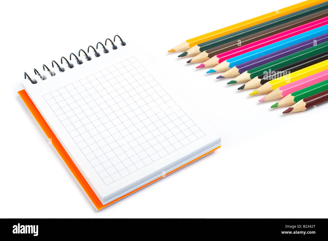 Blank notebook and assortment of coloured pencils with shadow on white ...