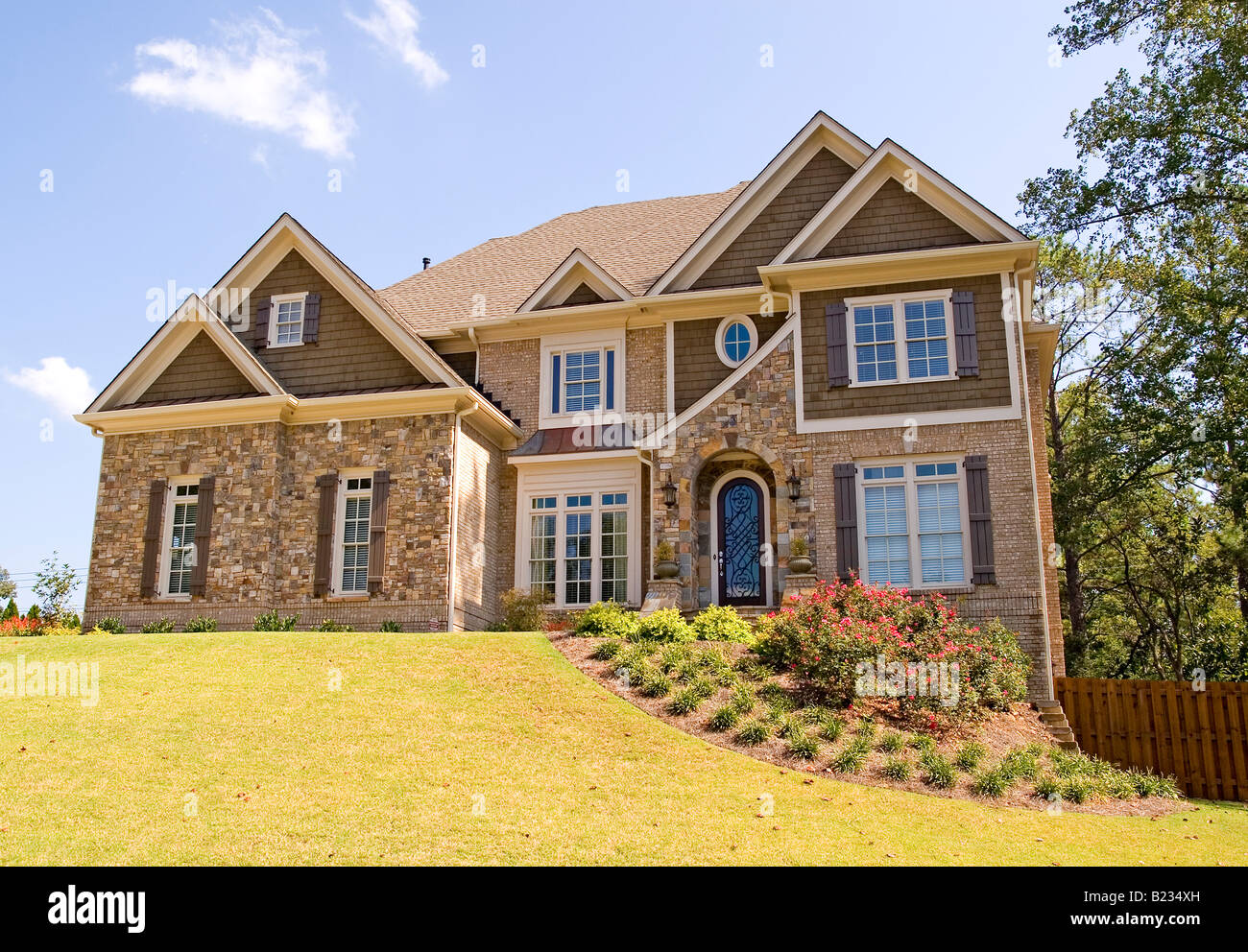 A nice stone and brick house on a landscaped hill Stock Photo - Alamy