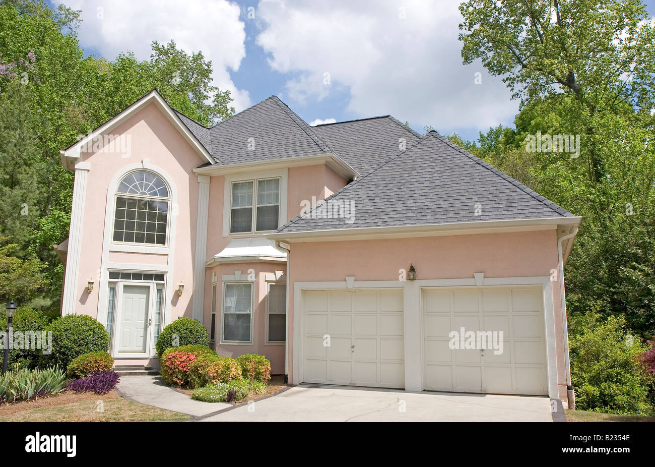 A nice pink stucco house with blue sky and clouds Stock Photo - Alamy