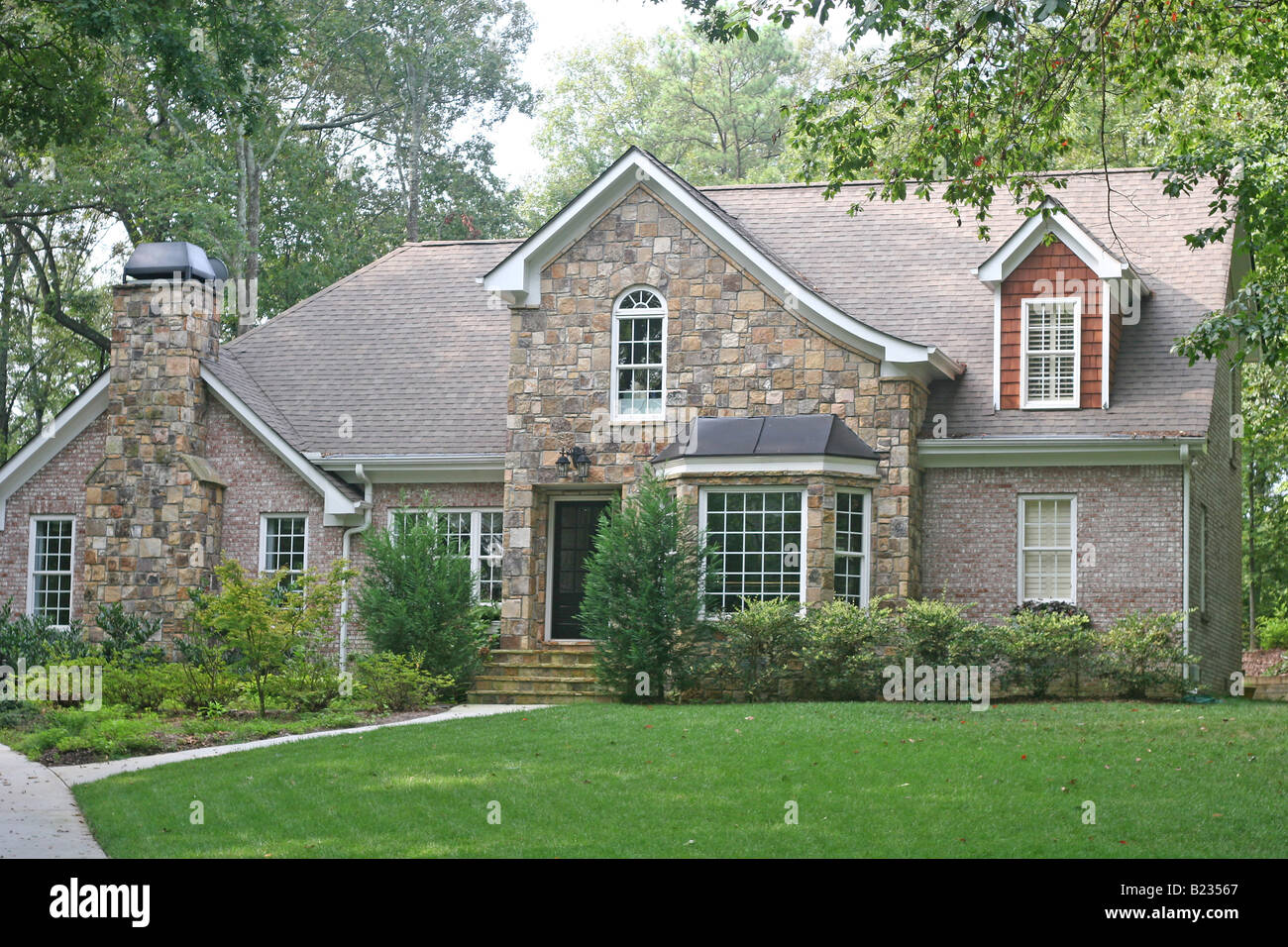 A nice stone and brick house on a grassy hill Stock Photo - Alamy
