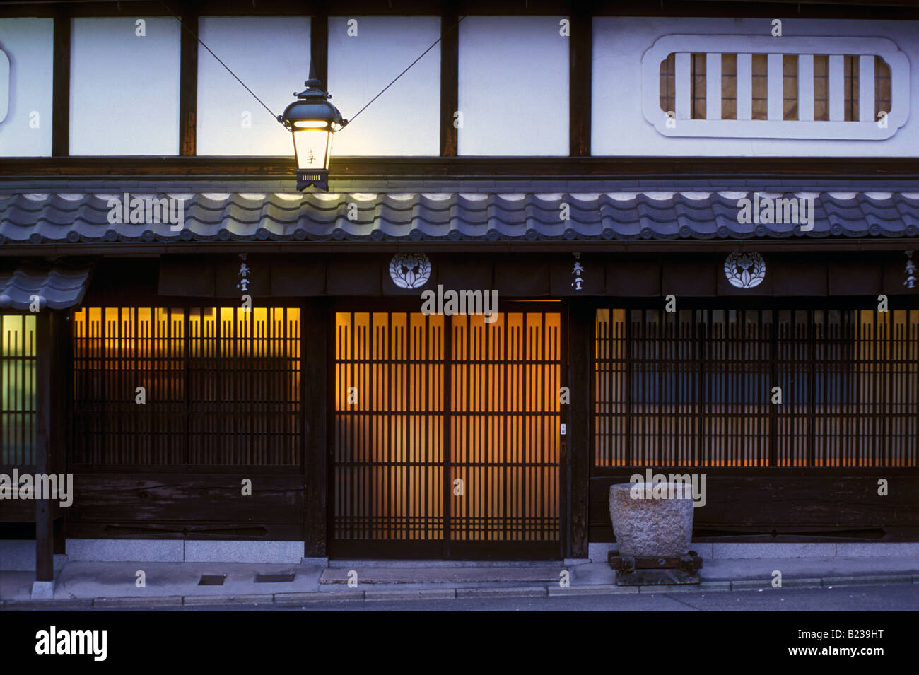Traditional merchant shop with glowing lantern above entrance in Kyoto ...