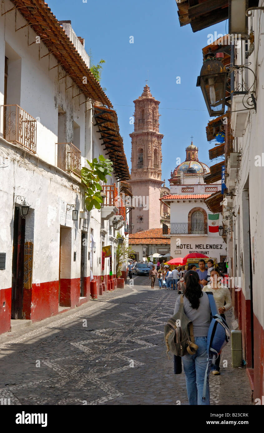 People in street with church in background San Sebastian y Santa Prisca ...