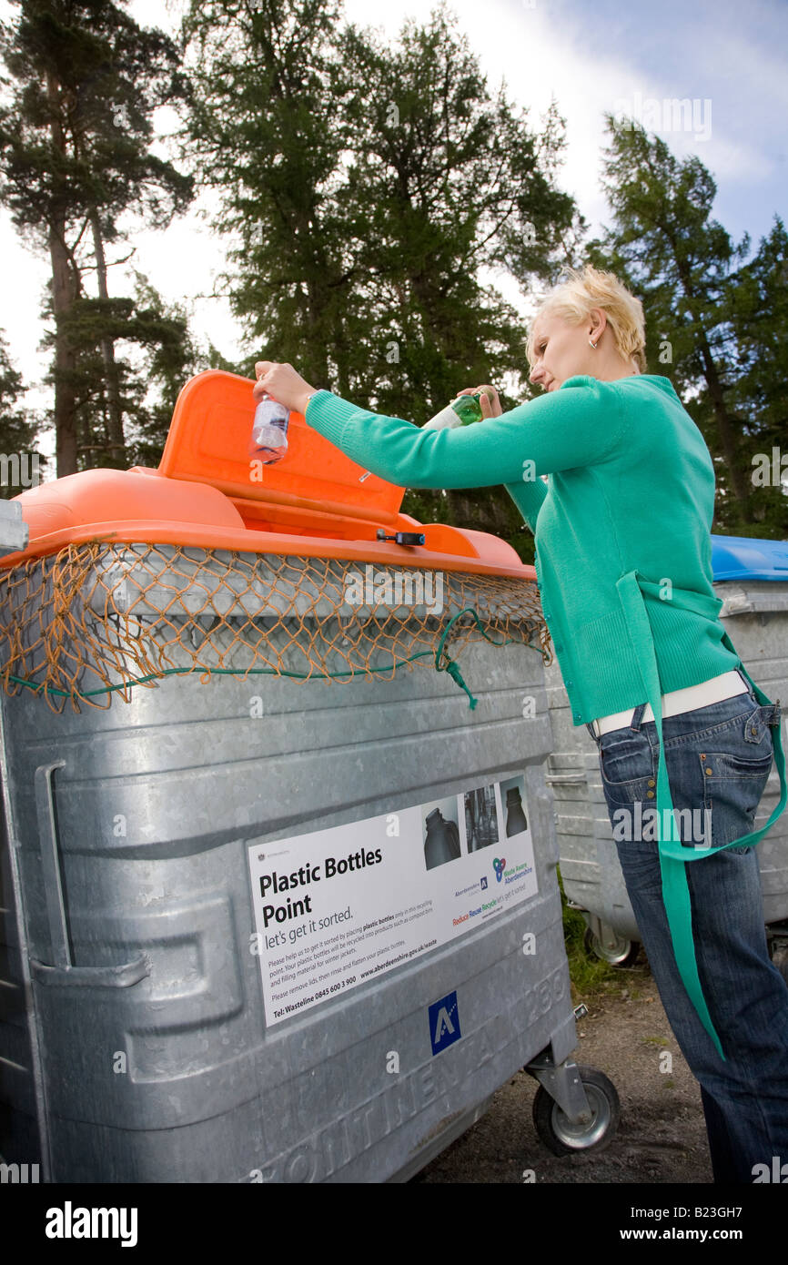 Woman placing materials in Recycling bin Stock Photo - Alamy
