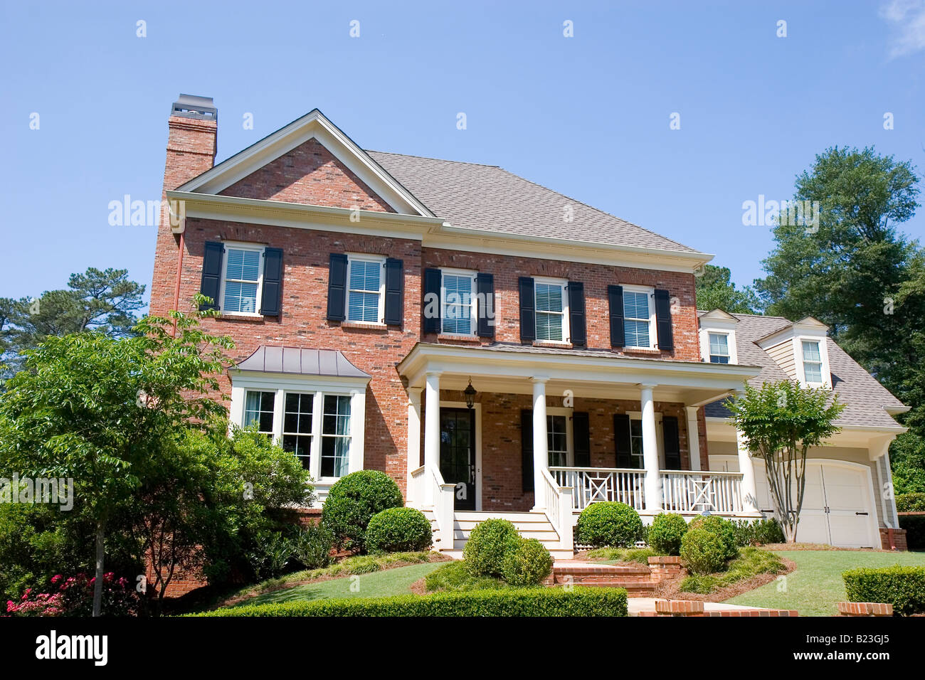A nice traditonal two story brick home with a porch Stock Photo - Alamy