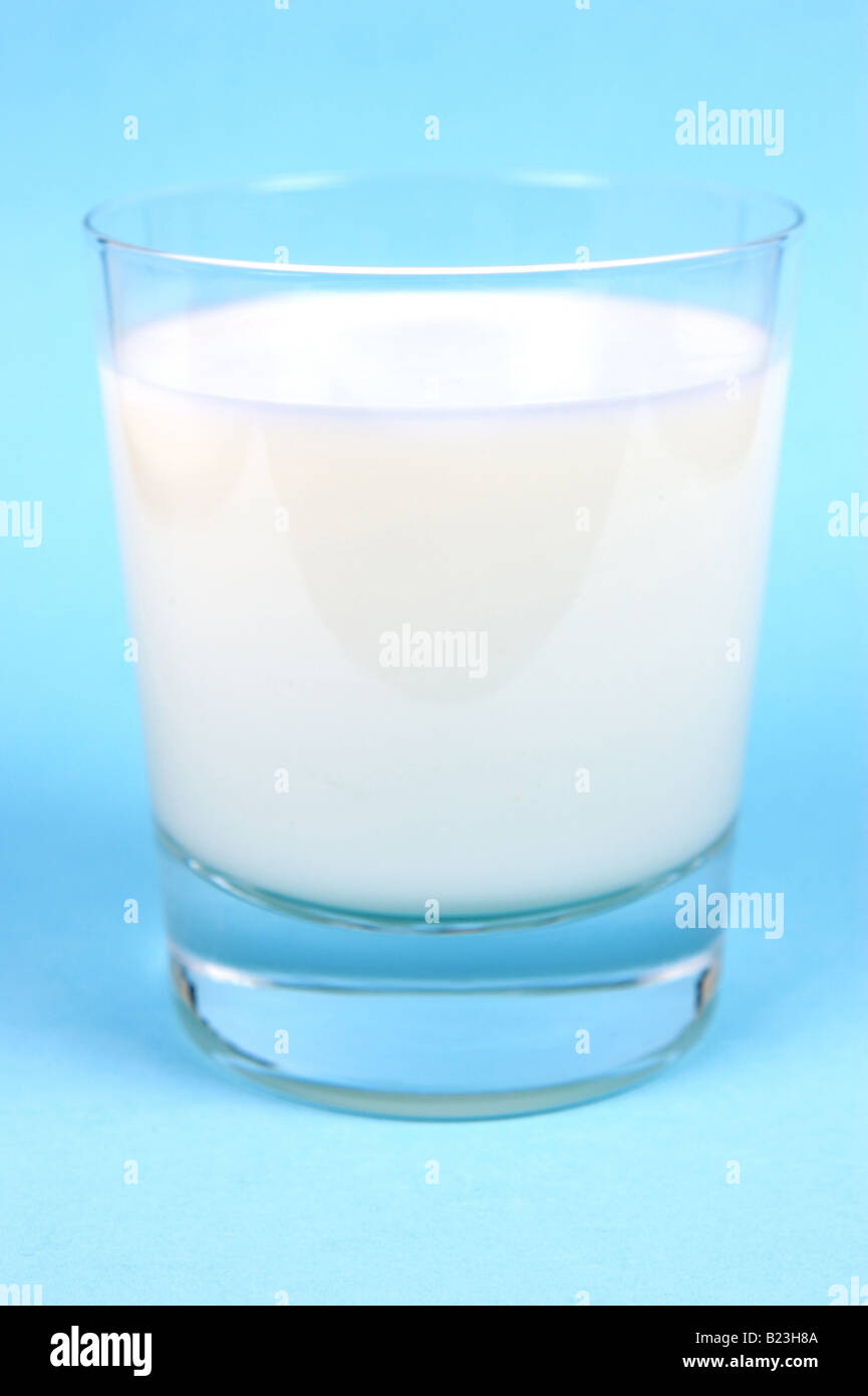 A glass of full cream milk isolated against a blue background Stock ...