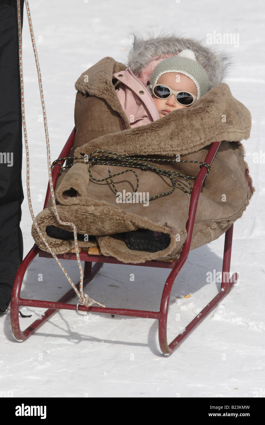 A young child is protected from cold. Child on sledge Stock Photo - Alamy