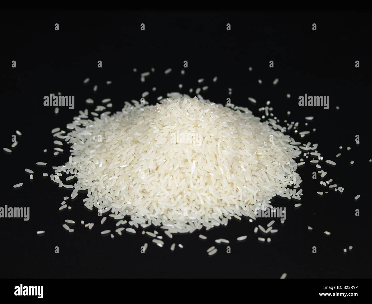 A pile of white long grained rice on a black surface Stock Photo - Alamy