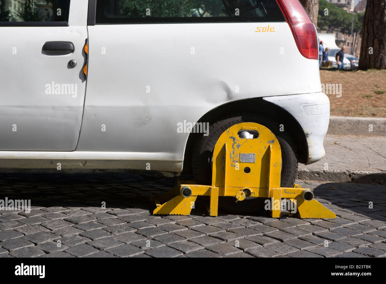 Yellow wheel clamp on white Fiat car Rome Italy Stock Photo - Alamy