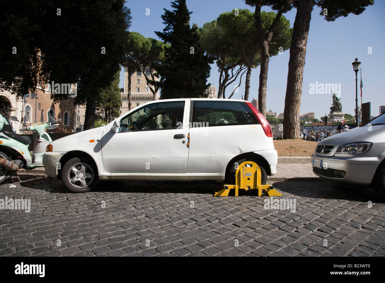 Yellow wheel clamp on white Fiat car Rome Italy Stock Photo - Alamy