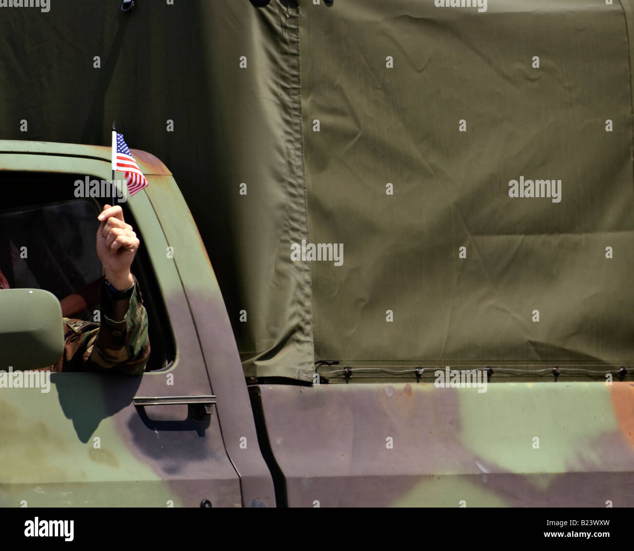 Hand waving American flag from window of US military vehicle Stock ...