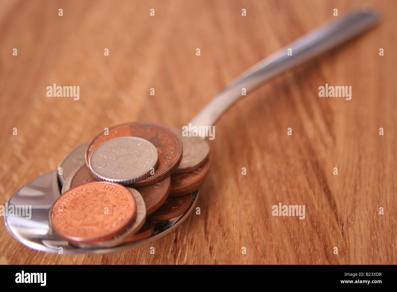 A spoon filled with money illustrates the rising cost of food Stock ...