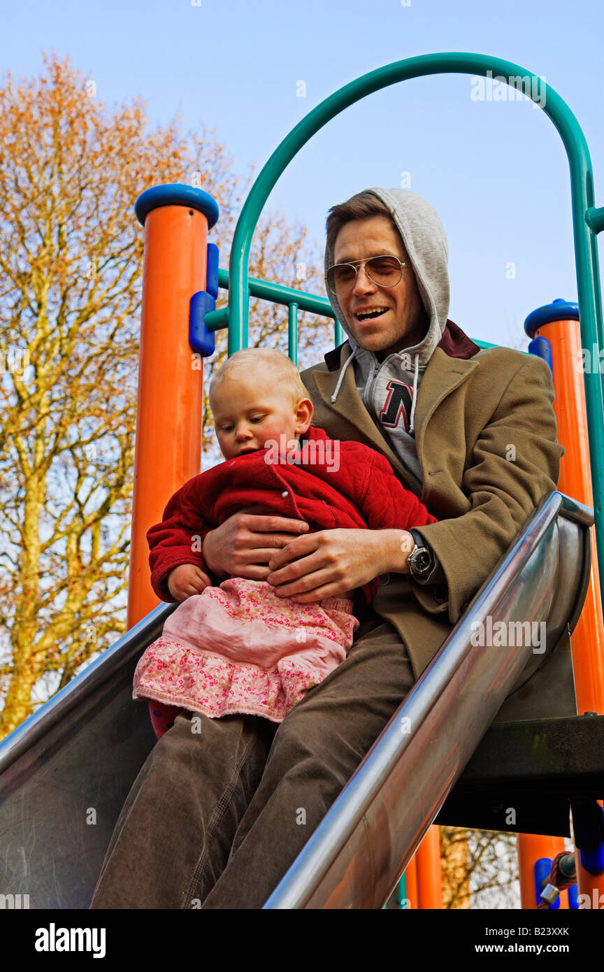Father and young child on playground slide Stock Photo - Alamy
