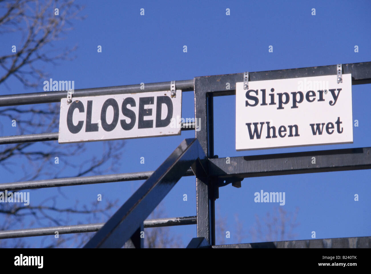 RAMP WITH CLOSED SIGN SLIPPERY WHEN WET SIGN Stock Photo - Alamy