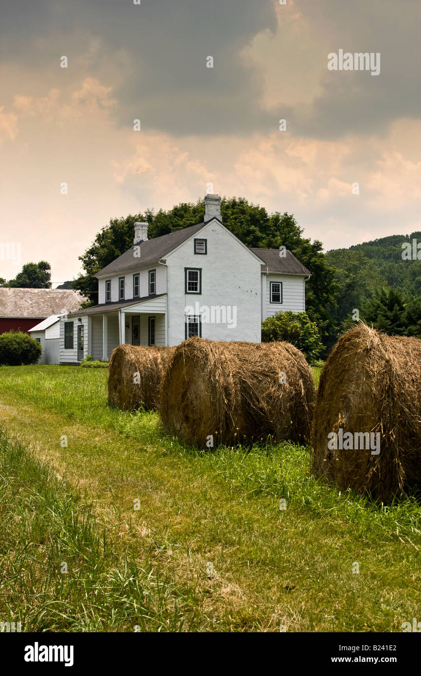 Charming white rural farmhouse in hay field Stock Photo - Alamy