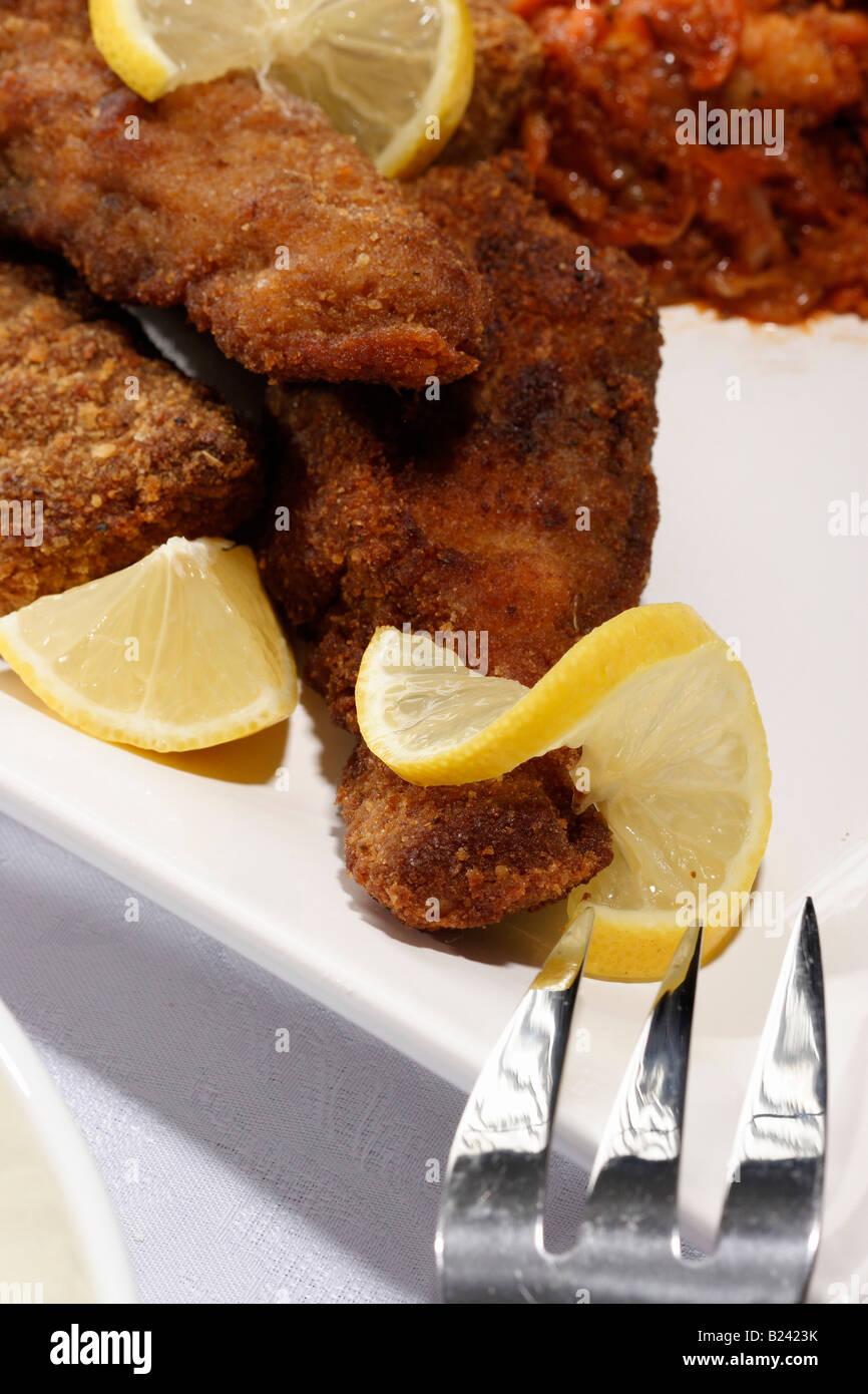 Fried fish fillets on a plate on a dining table overhead from above ...