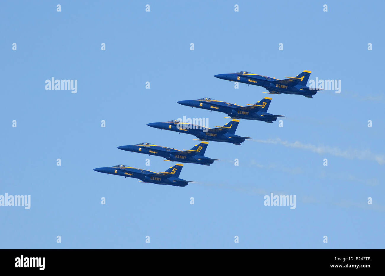 Five Blue Angels with yellow helmeted pilots flying in tight diagonal ...