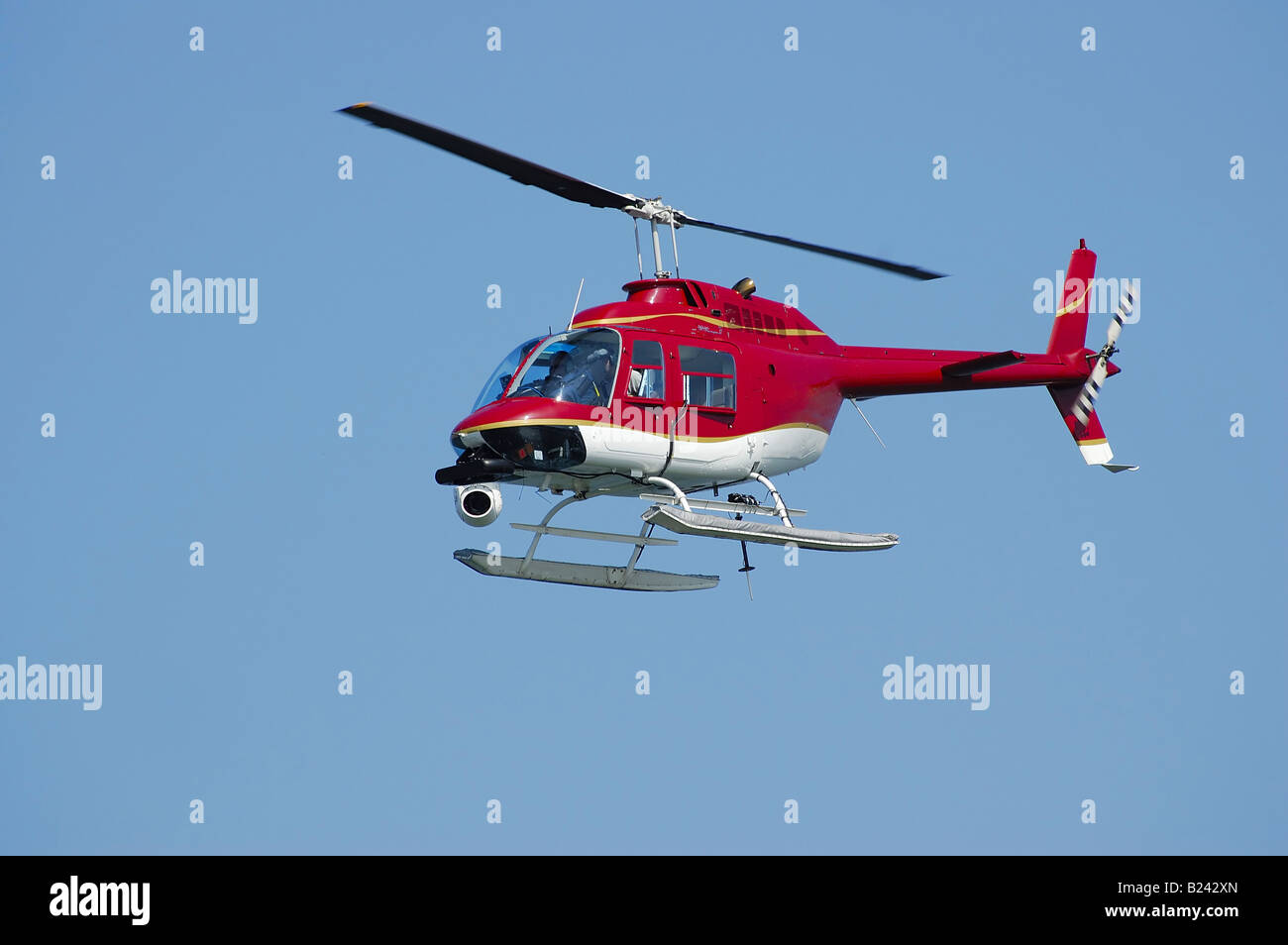 A bright red Bell 206 Jet Ranger helicopter with a camera on a Fleet ...