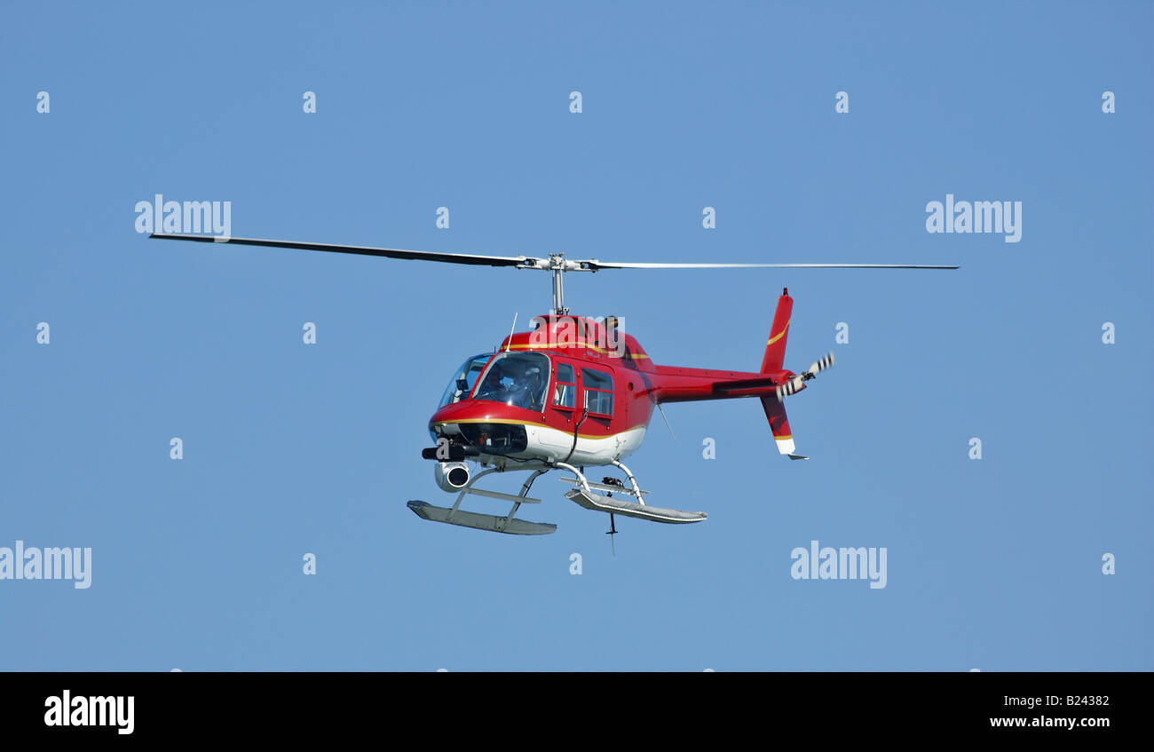 A bright red helicopter with a camera A little motion blur on rotor ...