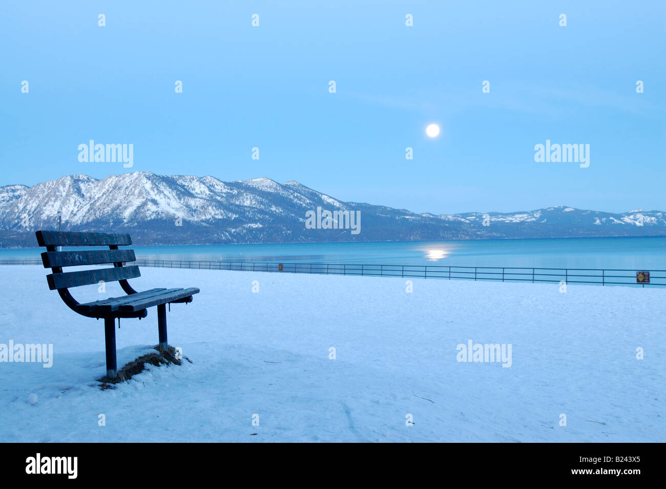 A bench on moonlit Regan beach at Lake Tahoe California The moon shines ...