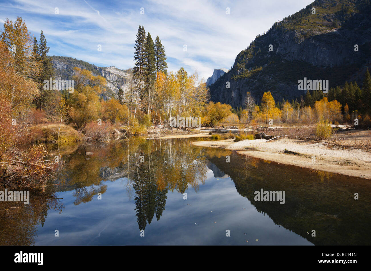 Half Dome is reflected in the calm waters of Merced River amid bright ...