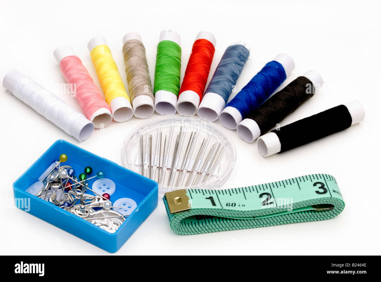 Sewing cotton reels with needles and tape measure Stock Photo - Alamy