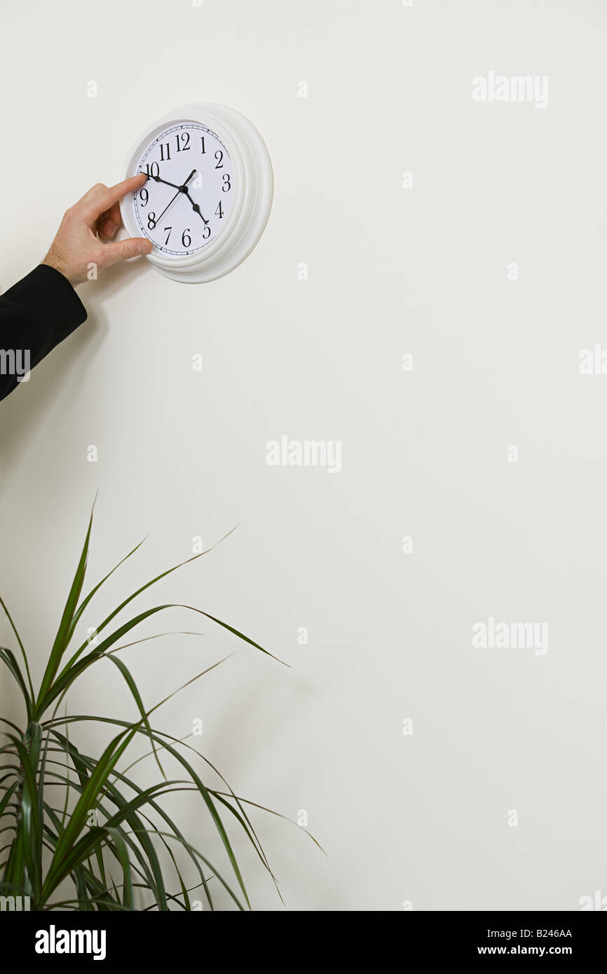 An office worker adjusting the hands on a clock Stock Photo - Alamy