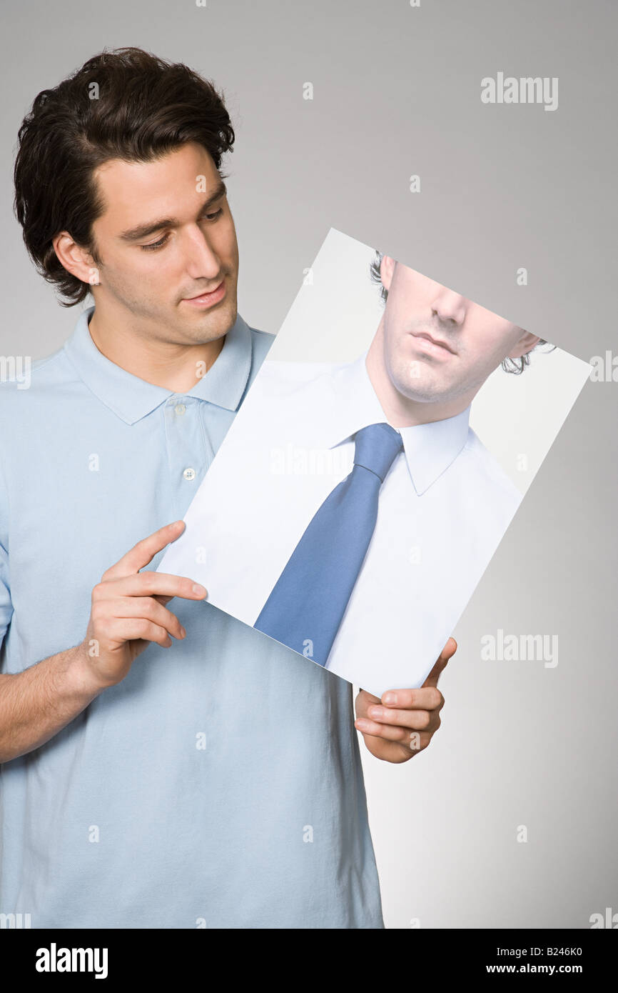 Portrait of a man holding a photograph of himself Stock Photo - Alamy