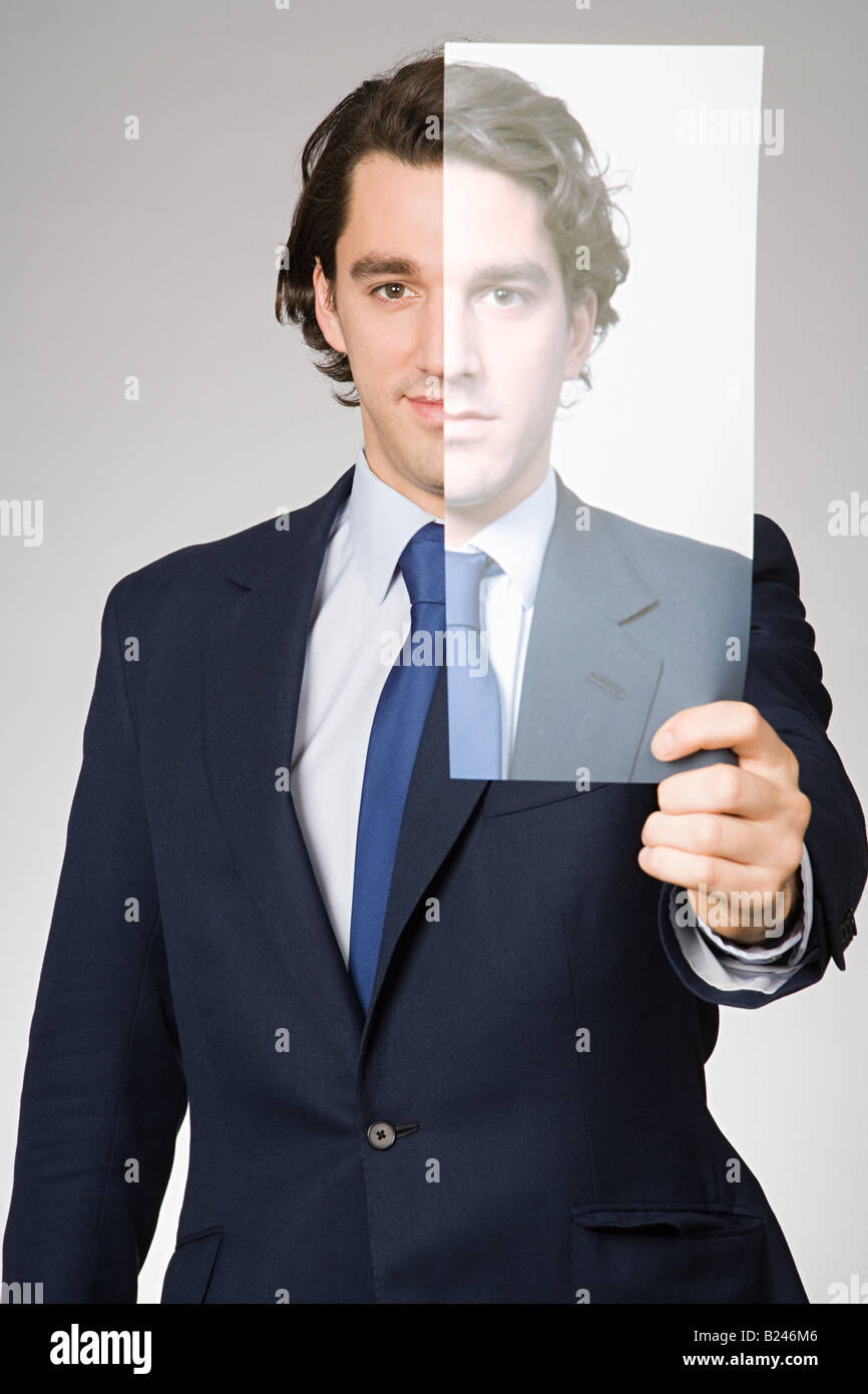 Portrait of a man holding a photograph of himself Stock Photo - Alamy