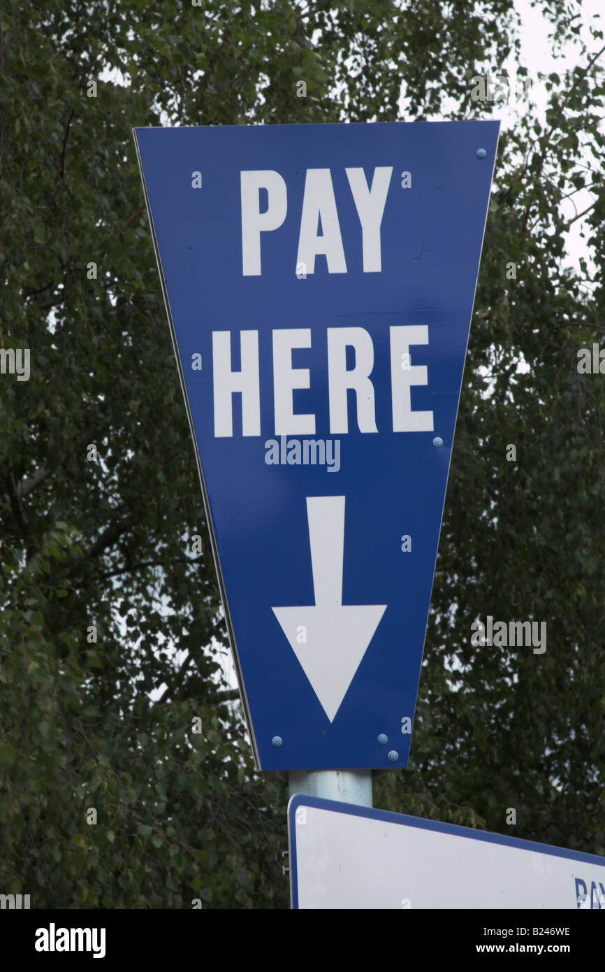 Pay Here sign and arrow pointing downwards Stock Photo - Alamy