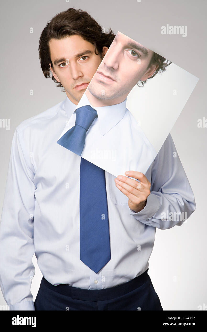 Portrait of a man holding a photograph of himself Stock Photo - Alamy