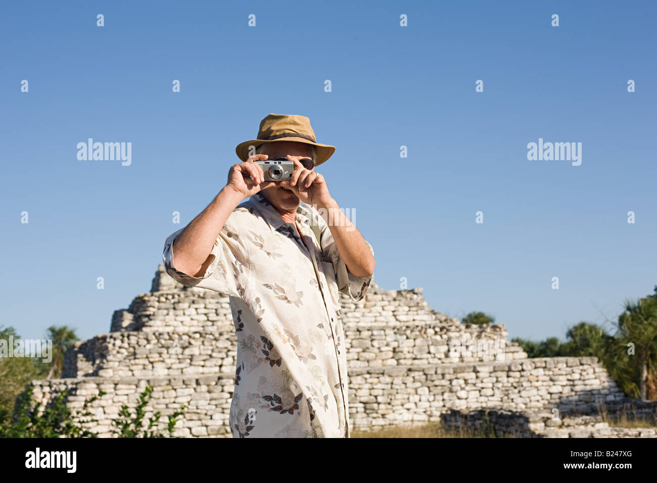 Man by ruins with camera Stock Photo - Alamy