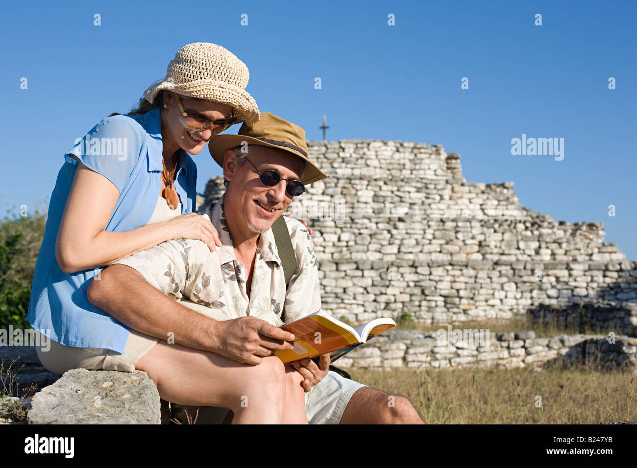 Couple by ruins with guidebook Stock Photo - Alamy