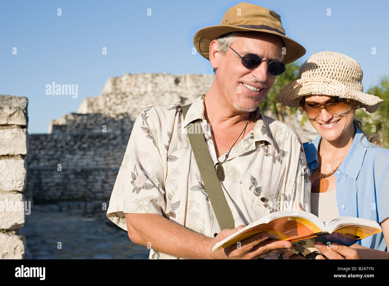 Couple by ruins with guidebook Stock Photo - Alamy