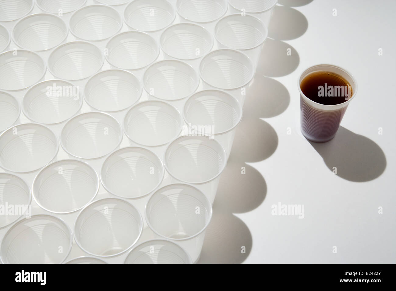 Cup of cola and rows of empty cups Stock Photo - Alamy