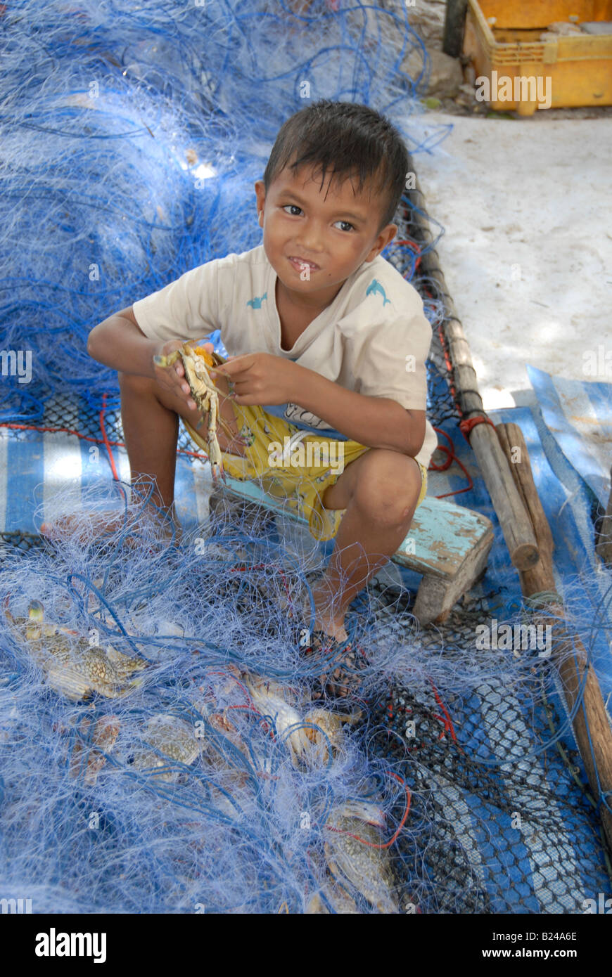 young boy cleaning nets of fish and crab Stock Photo - Alamy