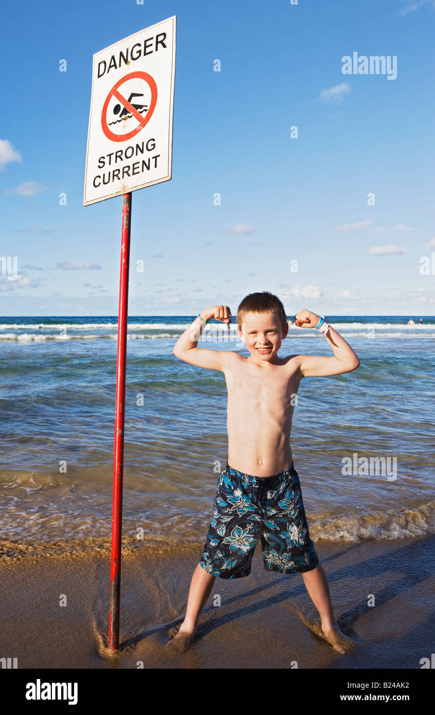 Boy flexing muscles by strong currents warning sign Manly Beach Sydney ...