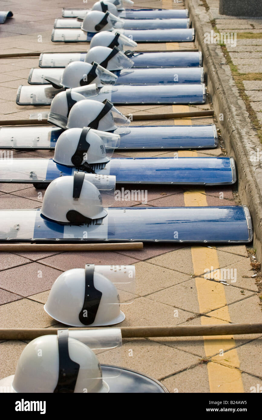 Riot shields, helmets and batons lined up on the ground prior to a ...