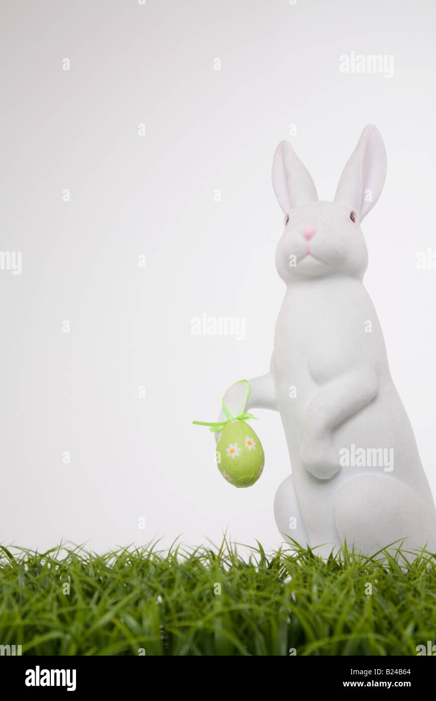 Easter bunny holding an easter egg Stock Photo - Alamy