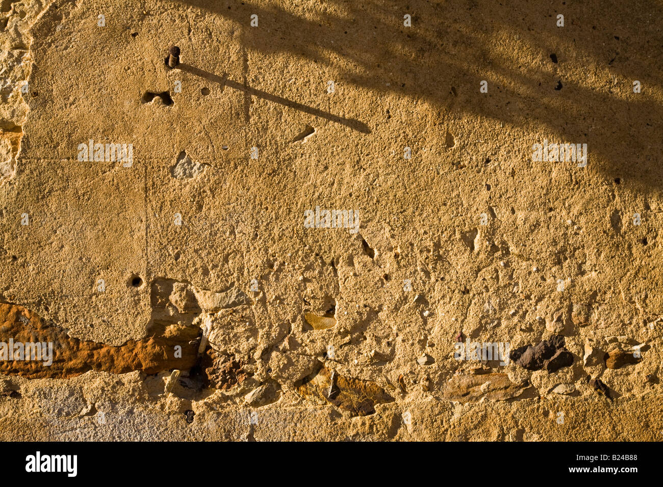 Crumbling course rendering over brick with nail and shadow Stock Photo ...