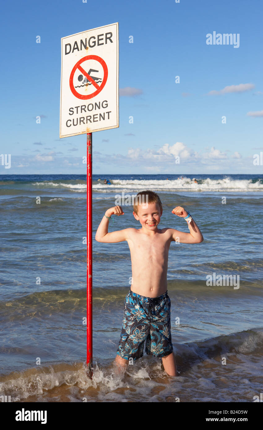 Boy flexing muscles by strong currents warning sign Manly Beach Sydney ...