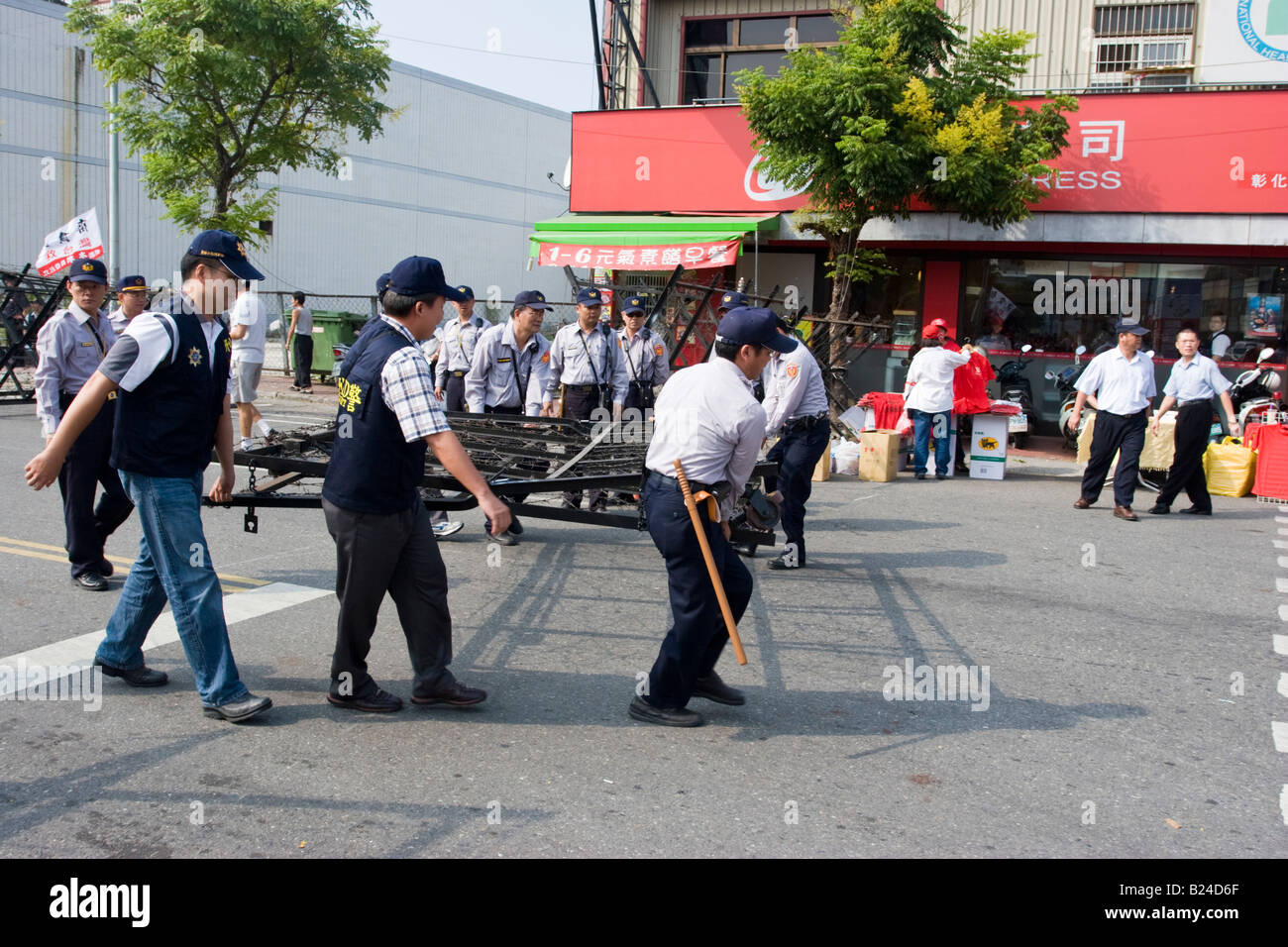 Police officers move a barbed wire barrier into place before a ...