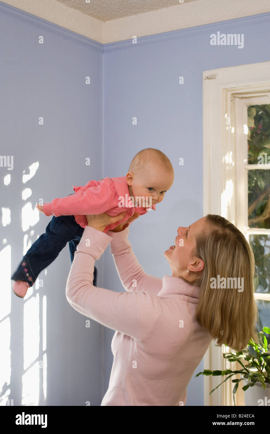 Mother lifting baby girl Stock Photo - Alamy