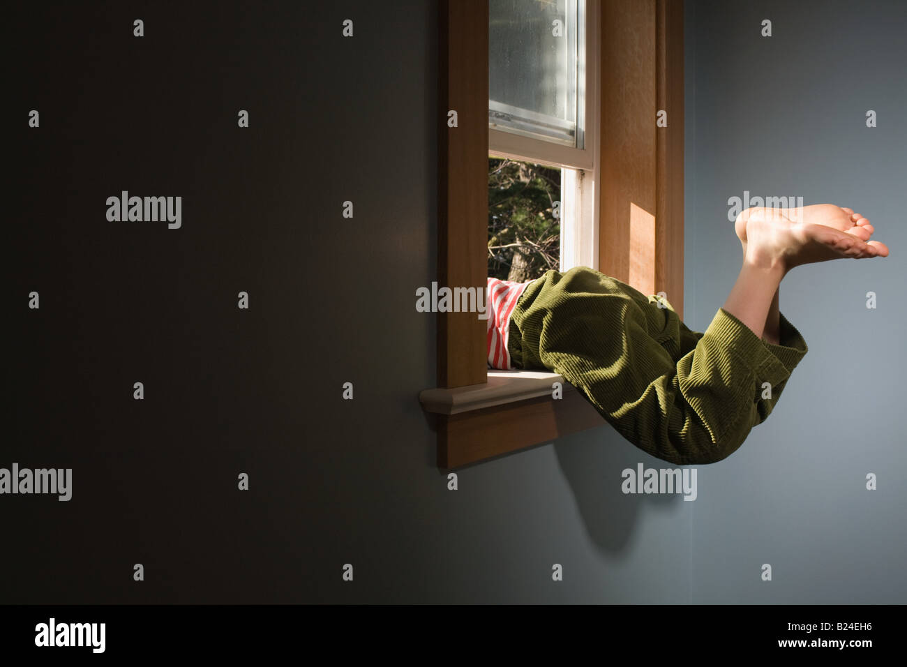 Boy climbing out of window Stock Photo - Alamy