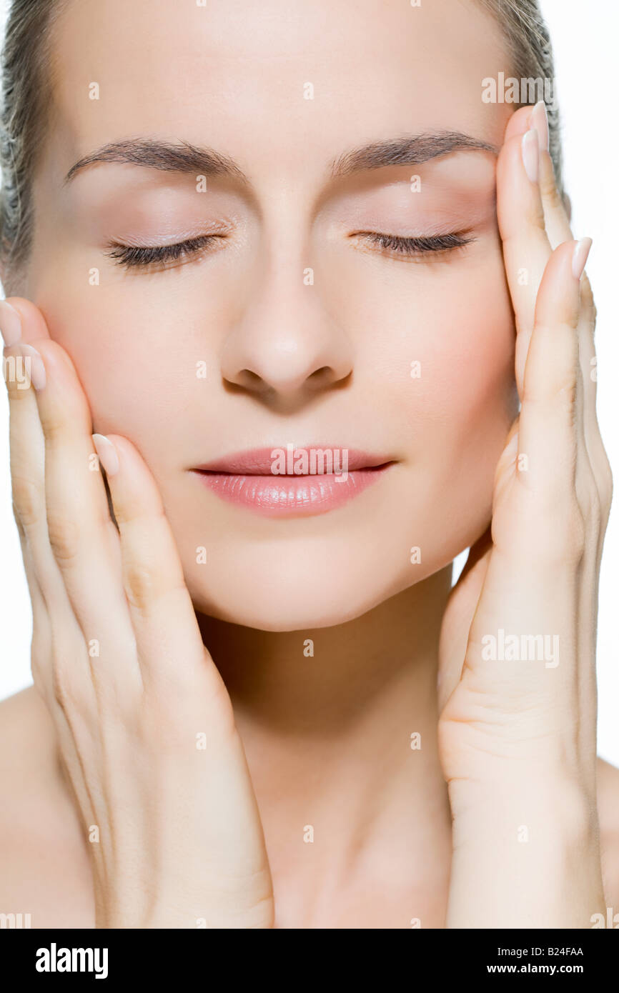 Woman touching face Stock Photo - Alamy