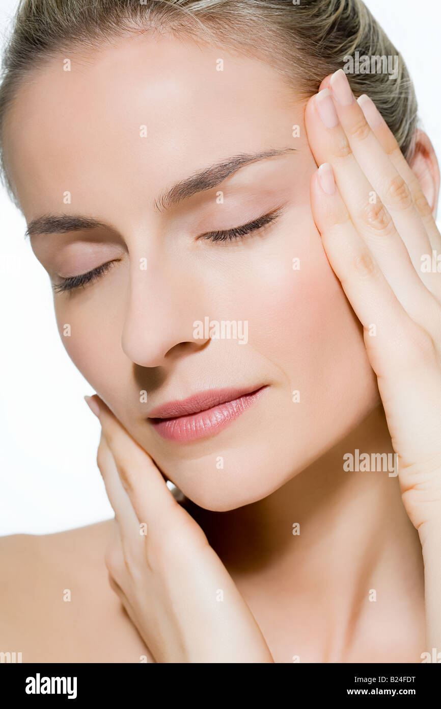 Woman touching face Stock Photo - Alamy