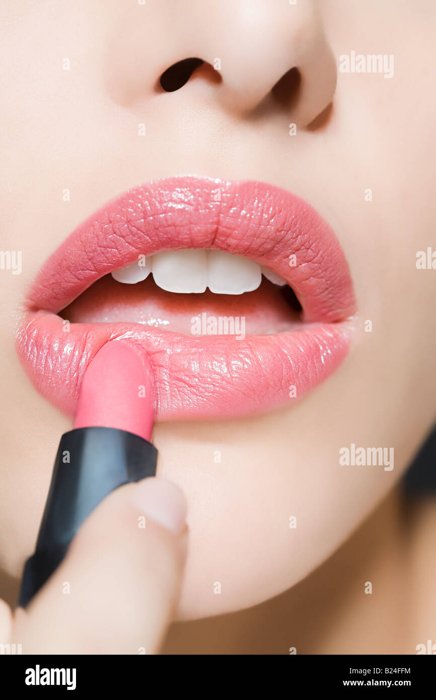 Woman applying lipstick Stock Photo - Alamy
