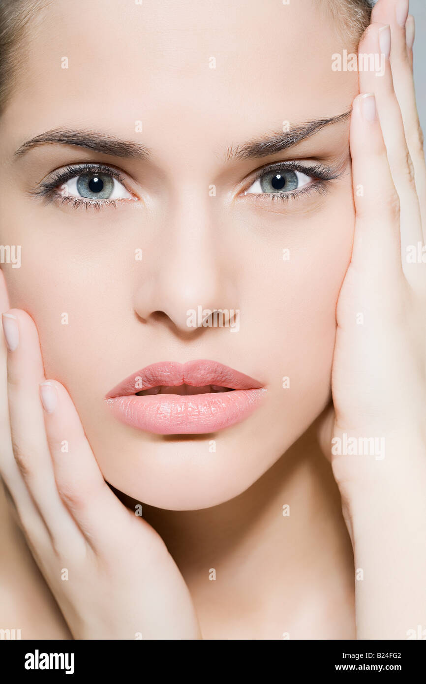 Woman touching face Stock Photo - Alamy