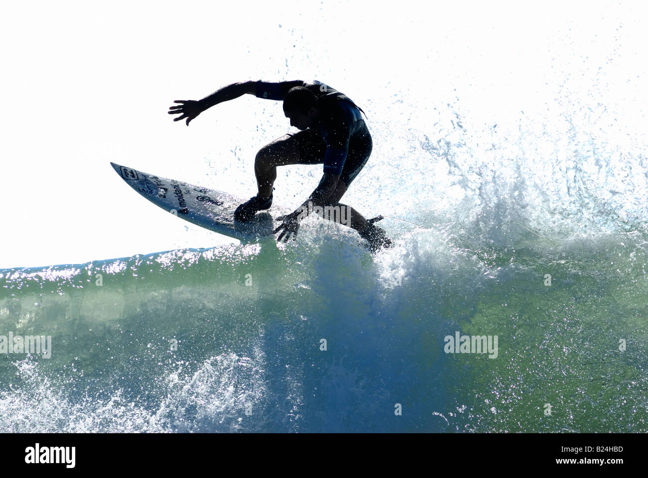 Surfer turning and getting airborne on top of breaking wave Stock Photo ...