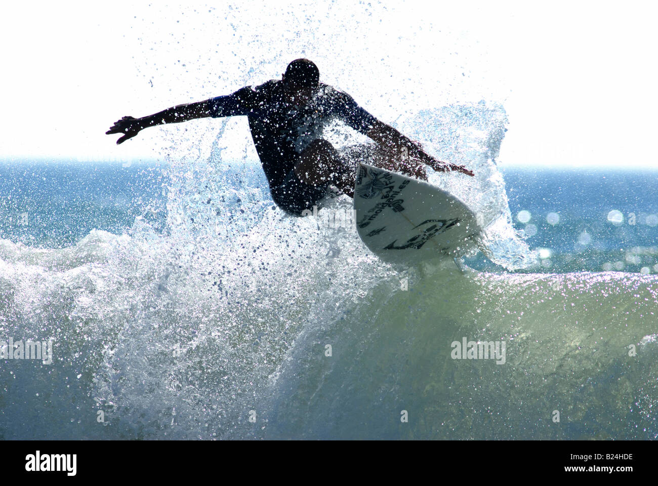 Surfer turning and getting airborne on top of breaking wave Stock Photo ...